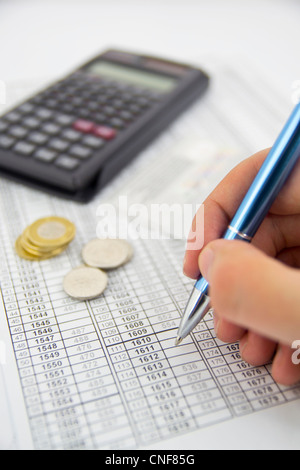 Pen and calculator with coins Stock Photo - Alamy