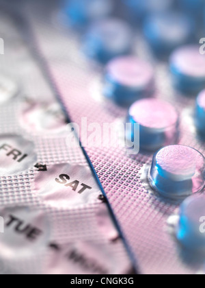 Oral contraception. Packet of contraceptive pills beneath light. These ...