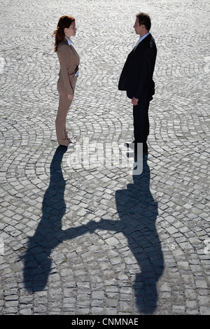 Businessman and woman shadows meeting outdoors in a plaza with a ...