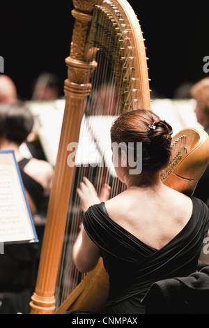 Harp player. Classical musician harpist playing harp. Female musician ...