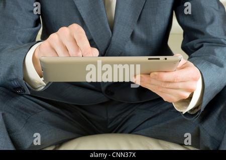 Hands holding tablet computer with business charts on screen against ...