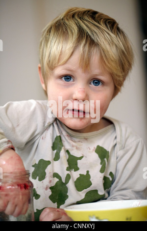 Boy eating jam from jar Stock Photo - Alamy