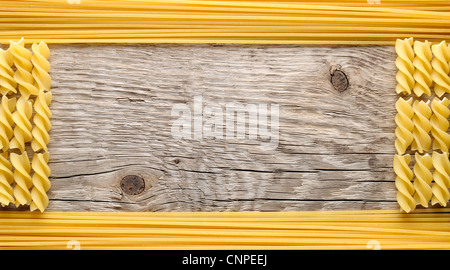 Frame made of pasta on old wooden background Stock Photo - Alamy