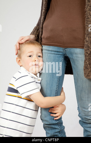 Boy hugging his mothers leg Stock Photo - Alamy