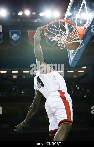 Slam Dunk. Side view of young basketball player making slam dunk Stock ...