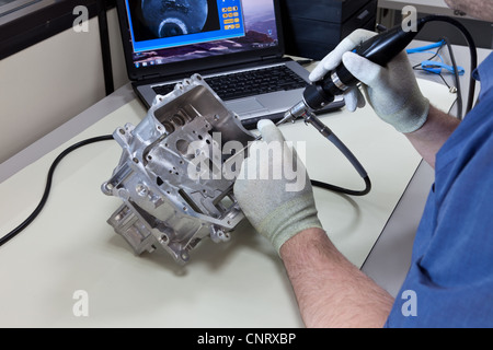 Video endoscopy. An employee checks a part of a gear case with the ...