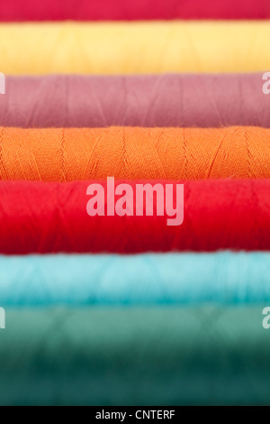 Spool of thread on blue background Stock Photo - Alamy