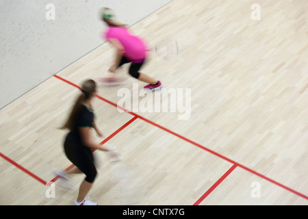 Two female squash players in fast action on a squash court (motion ...