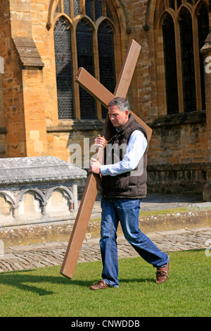 Christian Man carrying the Cross to mark the crucifixion of Jesus at ...