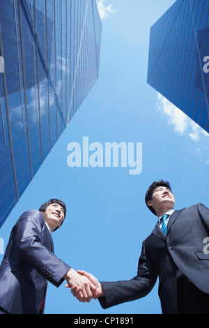 Businessmen shaking hands around the buildings Stock Photo - Alamy