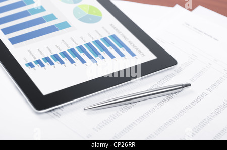 Modern tablet computer with business charts on screen against grey ...
