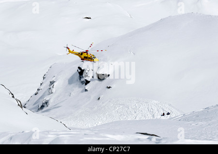 A rescue helicopter approaching an avalanche scene Stock Photo - Alamy