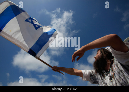 A religious Jew dance while waving Israeli flag at the seacoast ...