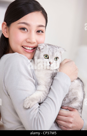 Smiling woman holding scottish fold cat near smartphone and breakfast ...