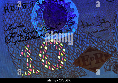 Banknote in ultraviolet light showing otherwise invisible security ...