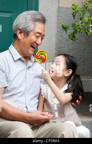 Chinese Grandfather and Grandaughter on front stoop Stock Photo - Alamy