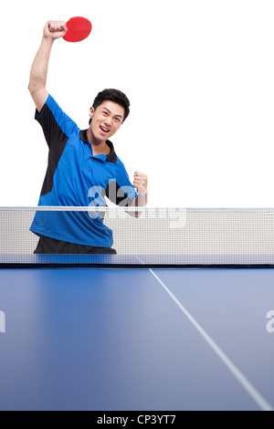 Asian table tennis player swings the racket posing isolated over white ...