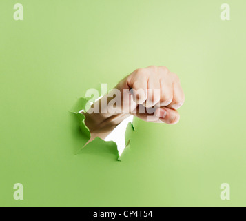 Man punching through green cardboard with his fist Stock Photo - Alamy