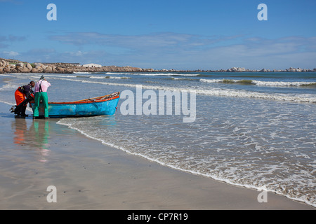 Two fishermen launching small fishing boat in Paternoster Stock Photo ...