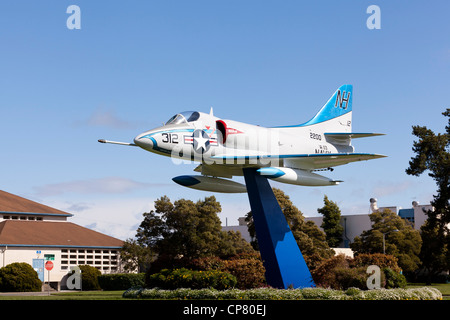 Fighter jet mounted for outdoor display. Against blue sky with upward ...