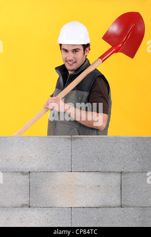 Builder stood with spade Stock Photo - Alamy