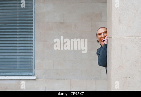 person wearing mask hiding behind hedge Stock Photo - Alamy