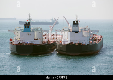 Two Oil tankers alongside each other performing "ship to ship" oil ...