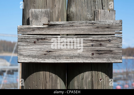 Old worn wooden notice board with scrap paper and rusty staples as ...