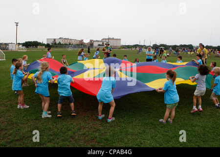 Elementary school age children enjoy lifting the parachute toss Stock ...