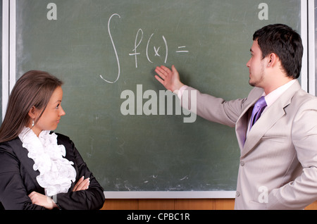 Young teacher and student doing exercise on blackboard Stock Photo - Alamy