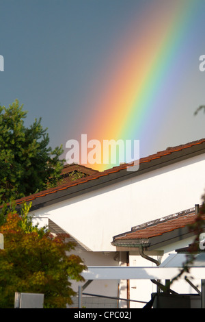 Rainbow over red roof tops Stock Photo - Alamy