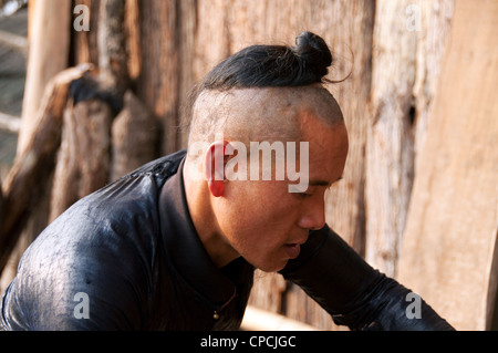 Traditional Basha hair shaving with a sickle on a man with a hair bun ...