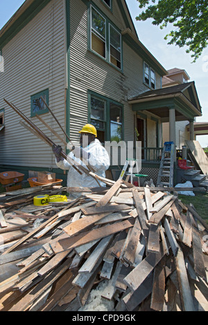 Workers salvage building materials from a home being "deconstructed ...