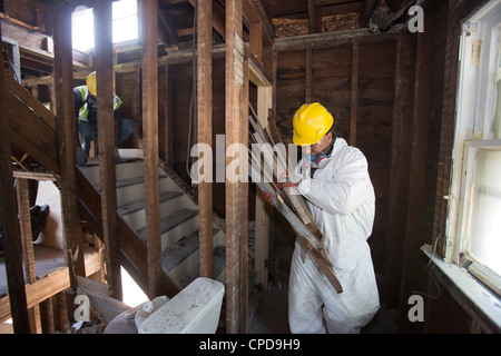 Workers salvage building materials from a home being "deconstructed ...