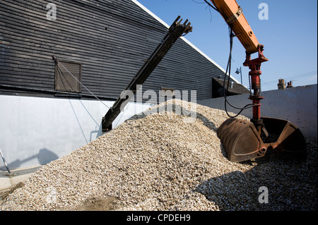 cockle shells piled into a mound with a mechanical grabber Stock Photo ...