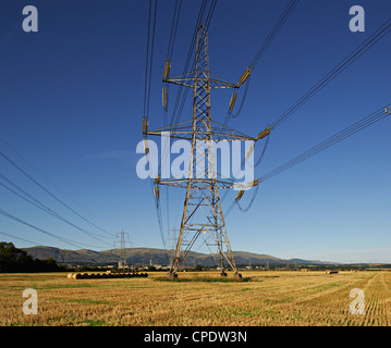 Electricity gantry with power lines against a cloudy sky Stock Photo ...