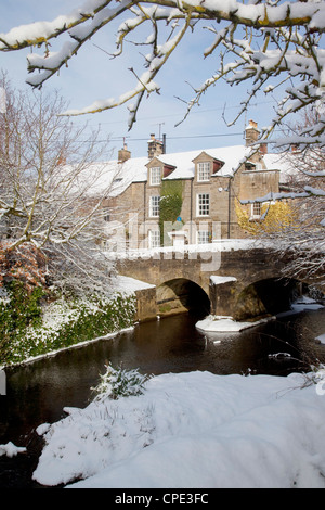 England, Derbyshire, Baslow, arch bridge over river with houses in ...