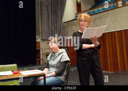 A group of actors rehearsing their lines, holding their scripts in ...
