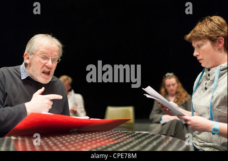 A group of actors rehearsing their lines, holding their scripts in ...