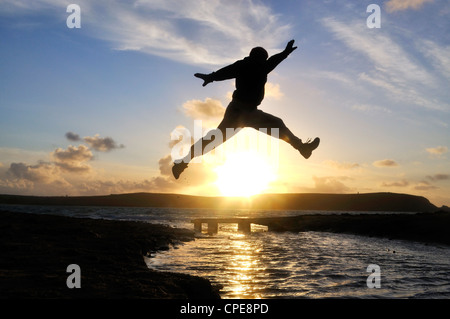 Silhouette of one man jumping over water at the beach Stock Photo - Alamy