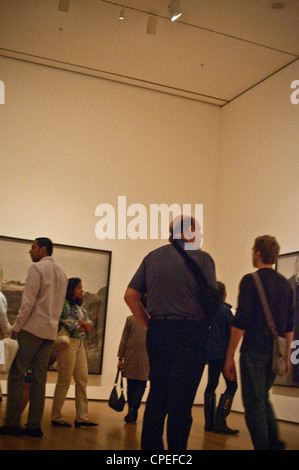 Visitors to the Museum of Modern Art watch a woman performing ...