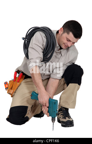 Muscular craftsman working with drilling machine Stock Photo - Alamy