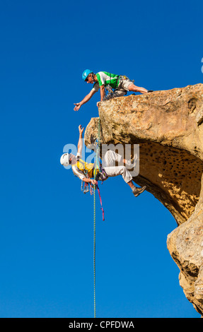 Climbing team struggle to the summit of a challenging rock mountain ...