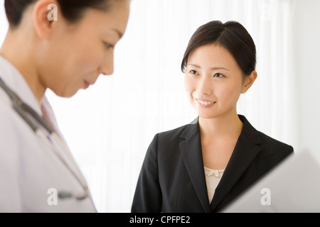 Pharmaceutical sales representative talking with female doctor in ...