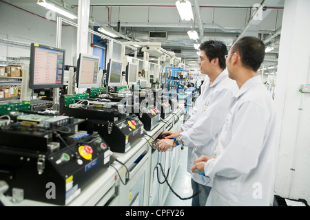 Workers assemble hand-held inventory computer devices on the assembly ...