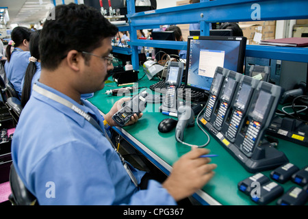 Workers test hand-held inventory computer devices on the assembly line ...