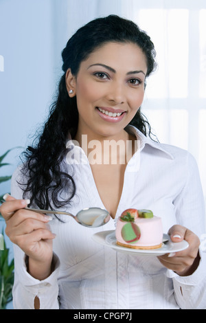 Young woman eating custard, portrait Stock Photo - Alamy
