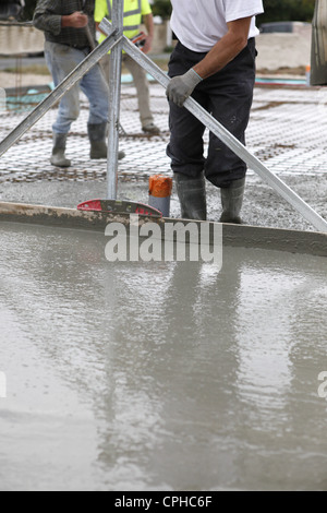 Bricklayer construction worker putting down another row of cement ...