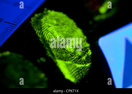 Crime scene fingerprint highlighted on a knife blade in a forensic ...