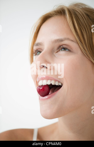 Young woman eating cherry Stock Photo - Alamy
